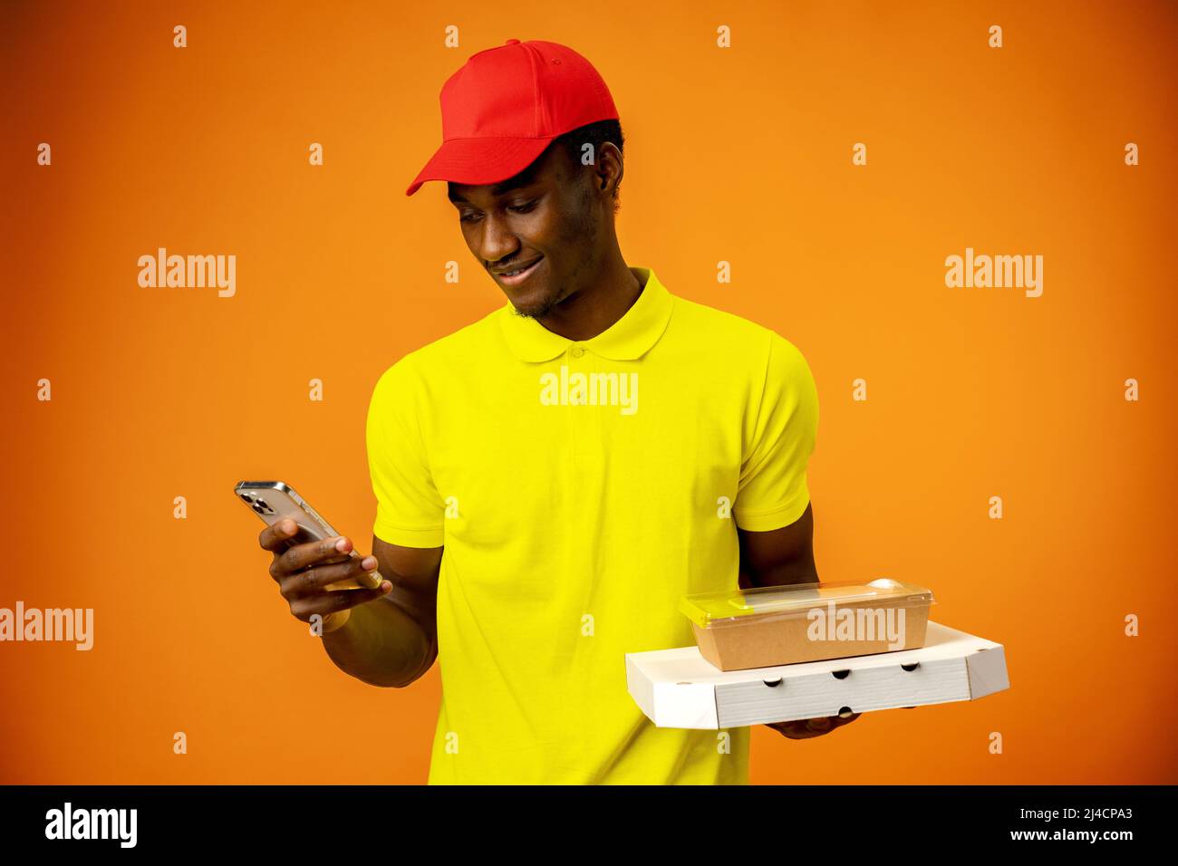 African delivery man wearing courier uniform holding cardboard parcel ...