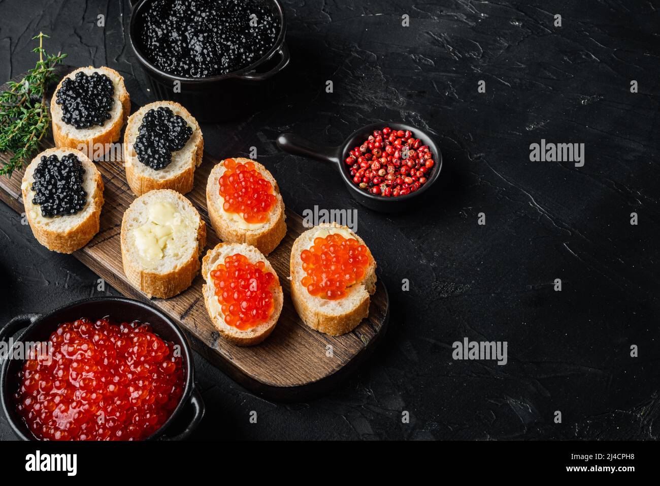 Sandwiches with red and black caviar baguette, on black background with ...