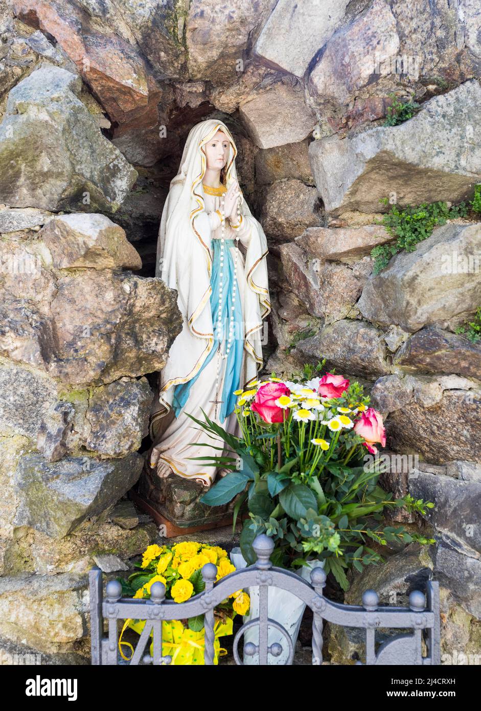 Virgin Mary figure with rosary and flowers, Virgin Mary fountain next ...