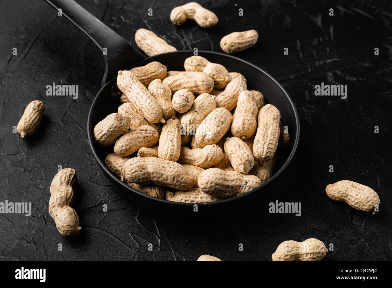 Peanuts serving to make oil, peanut butter set, on black dark stone ...