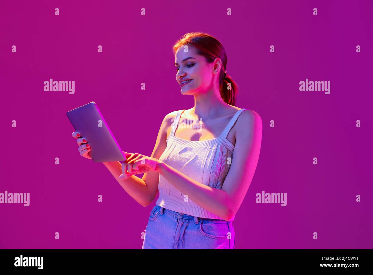 Young beautiful happy girl wearing casual style clothes using tablet ...