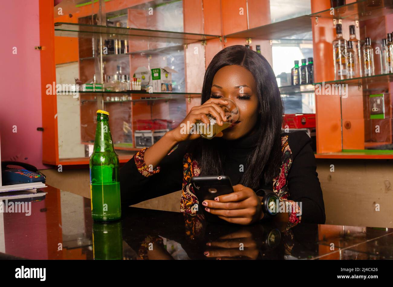 beautiful Alcoholic lady using her cellphone Stock Photo - Alamy