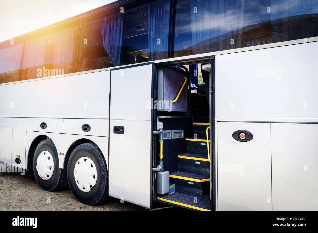 Side of a large white tourist bus with an open door Stock Photo - Alamy