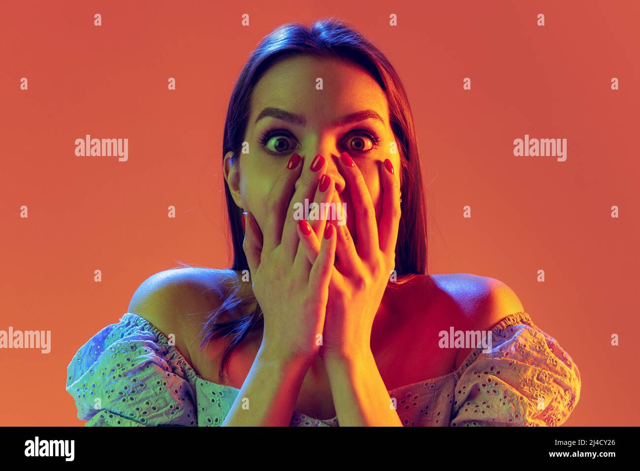 Scared young girl with long shiny hair isolated on peach color ...