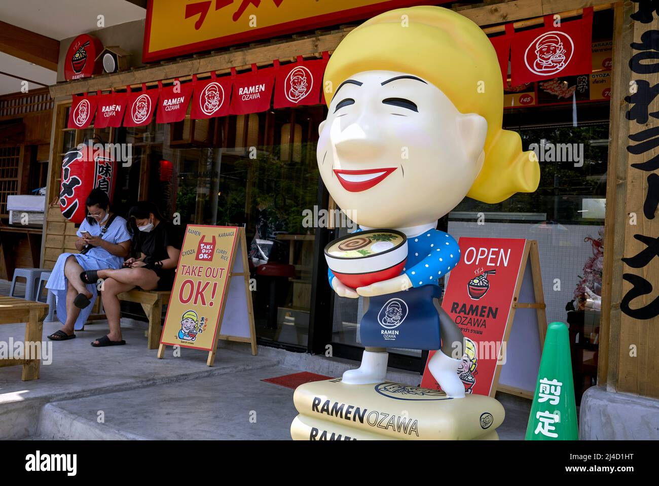 Japanese restaurant exterior with large colorful statue of a serving ...