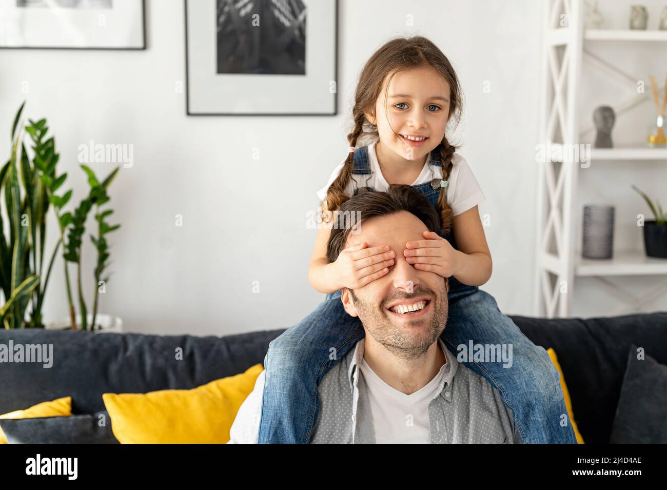 Cute girl closed eyes to her father. Loving father carrying his little toddler daughter on the ...