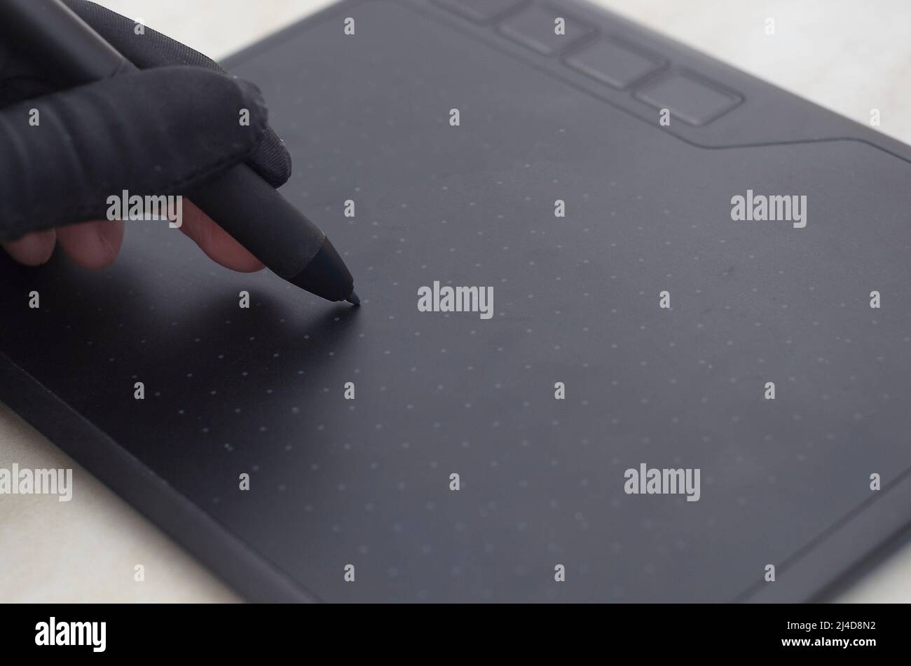 Graphic designer's hand in a black glove draws on the workspace of a ...