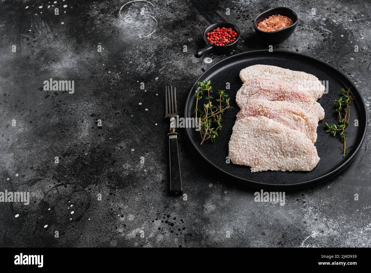 Uncooked Wiener Schnitzel, breaded steak ready to cook set, on black ...