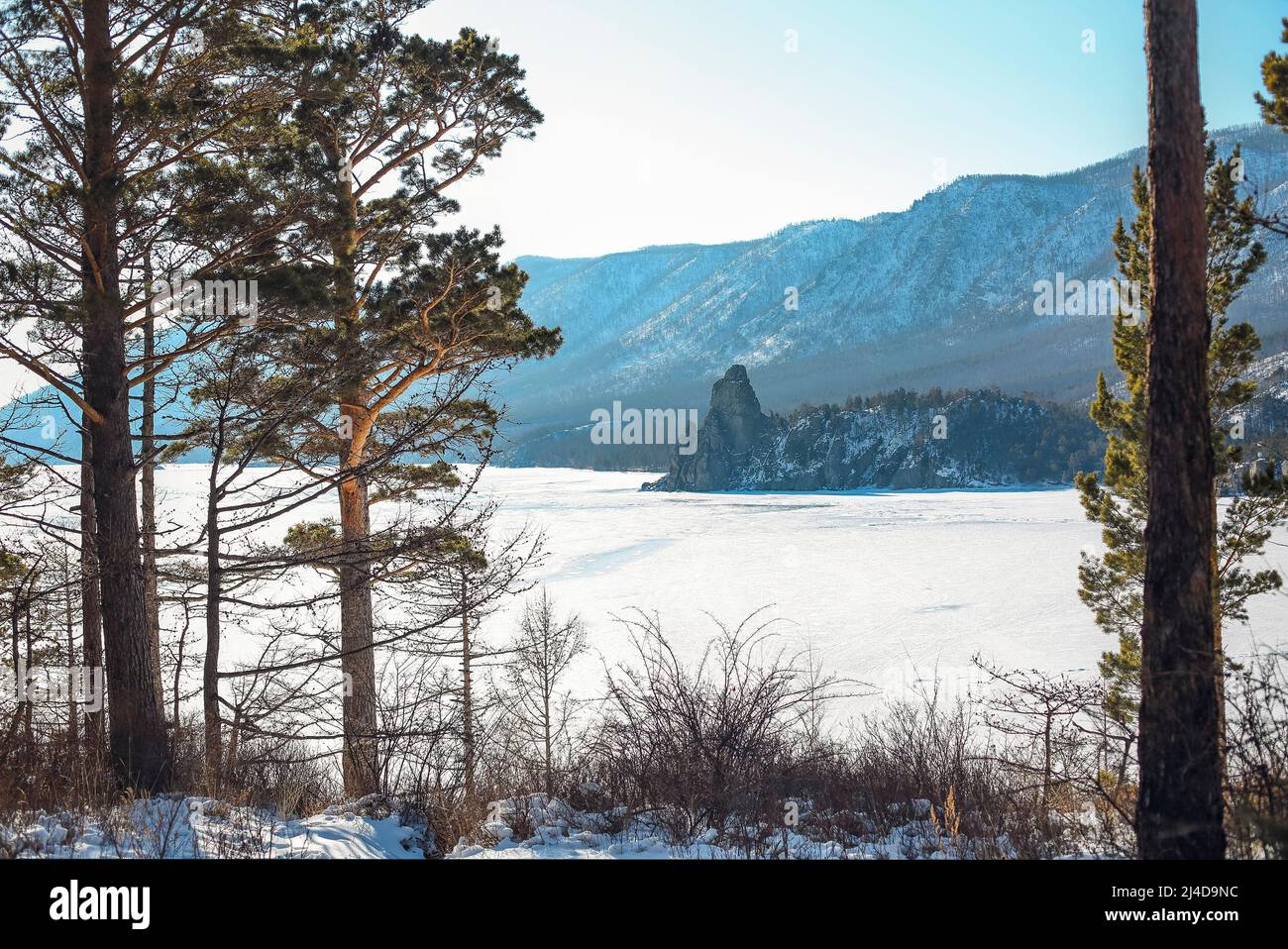 Aerial view of a sandy bay, mountains and blue ice of frozen Lake ...
