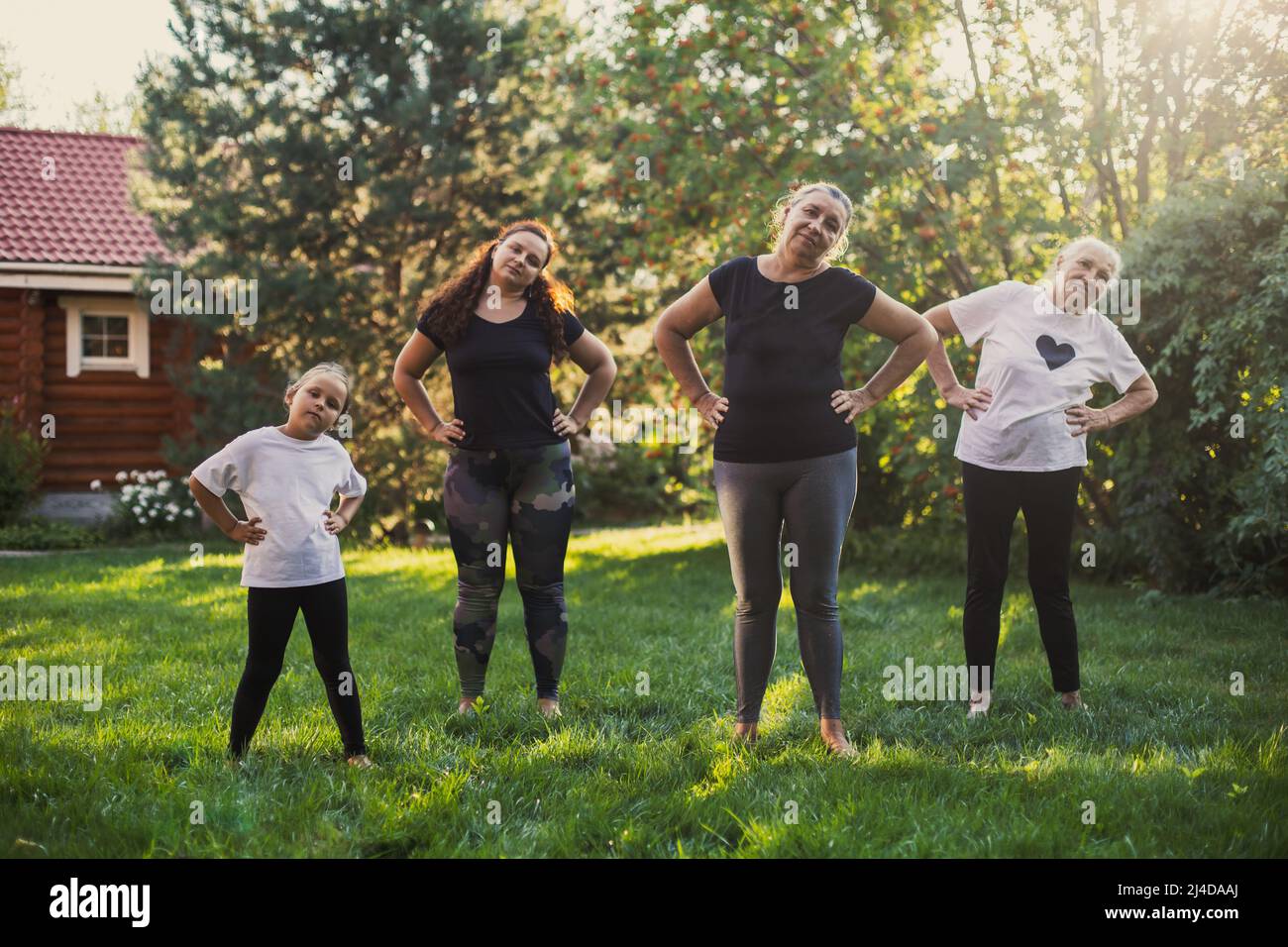 Family with females of few generations doing sports outside stretching ...
