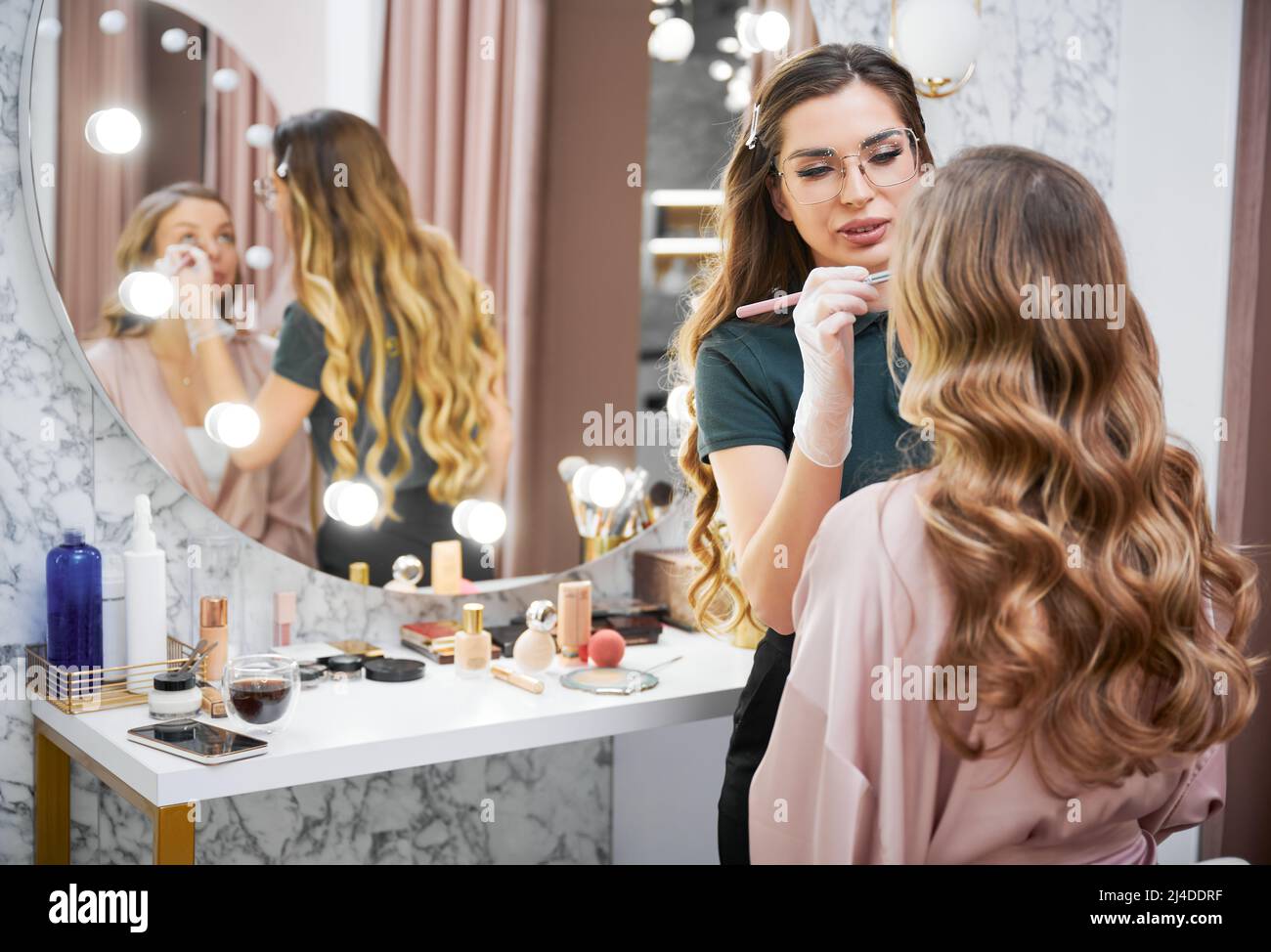 Visagiste doing makeup client sitting hi-res stock photography and ...