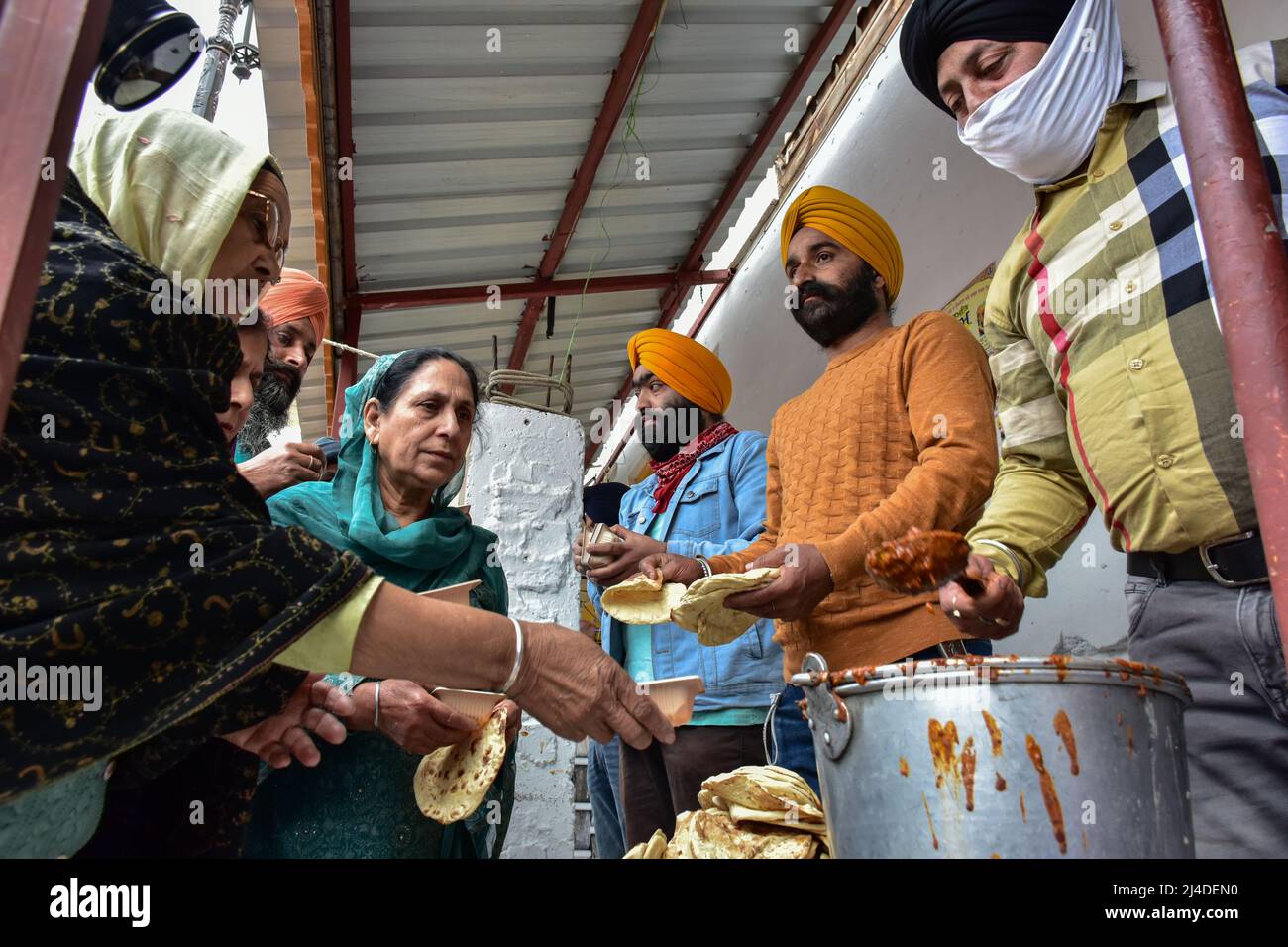 Volunteers provide food among the Sikh devotees inside a Gurdwara or a ...