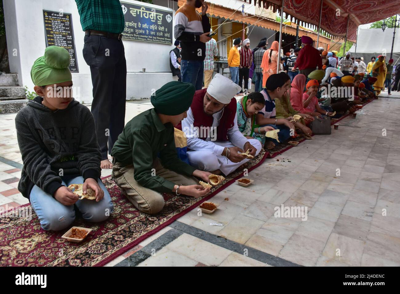 Sikh devotees eat food inside a Gurdwara or a Sikh temple on the ...
