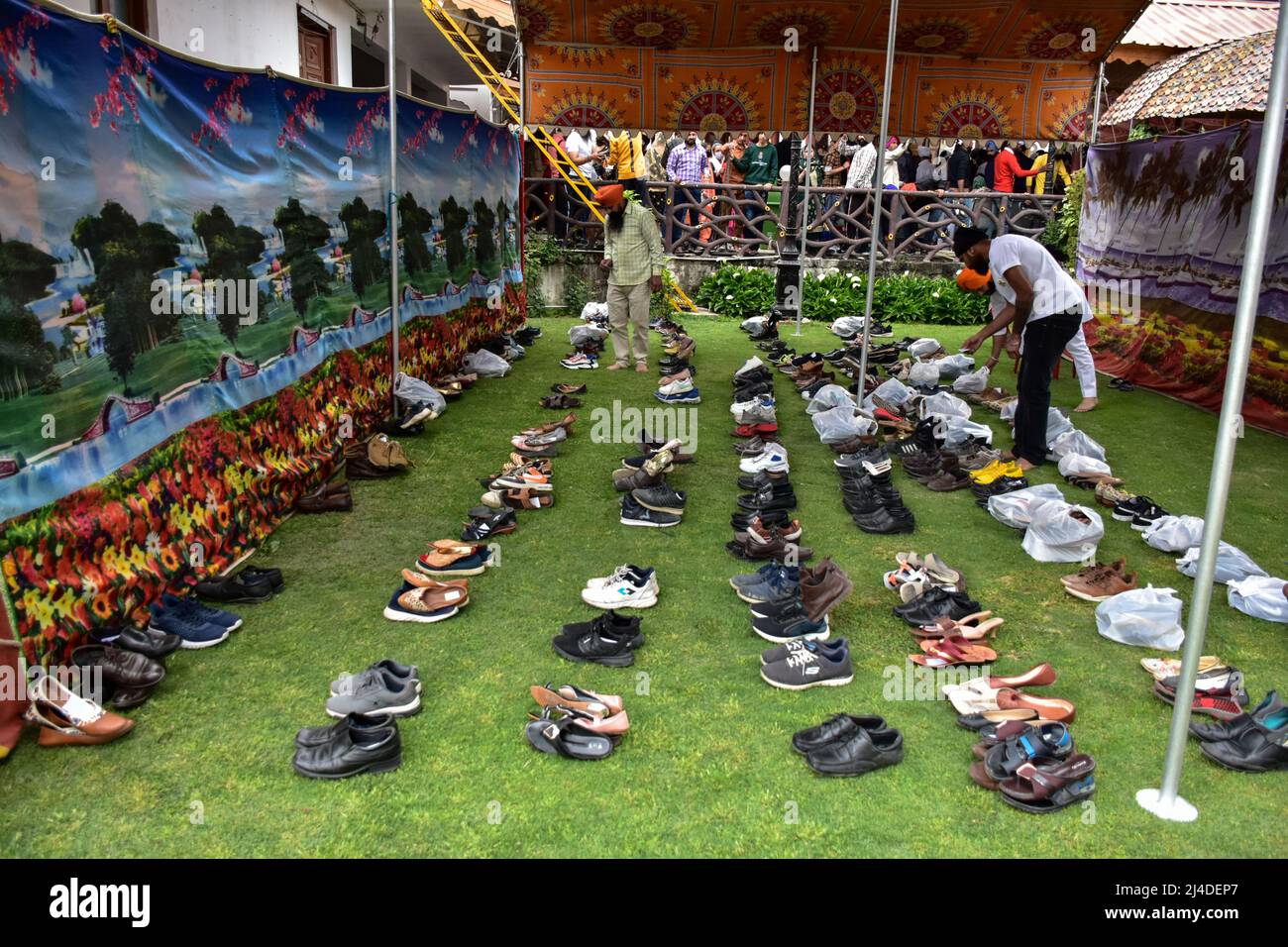 Volunteers arrange and clean shoes of Sikh devotees at a Gurdwara or a ...