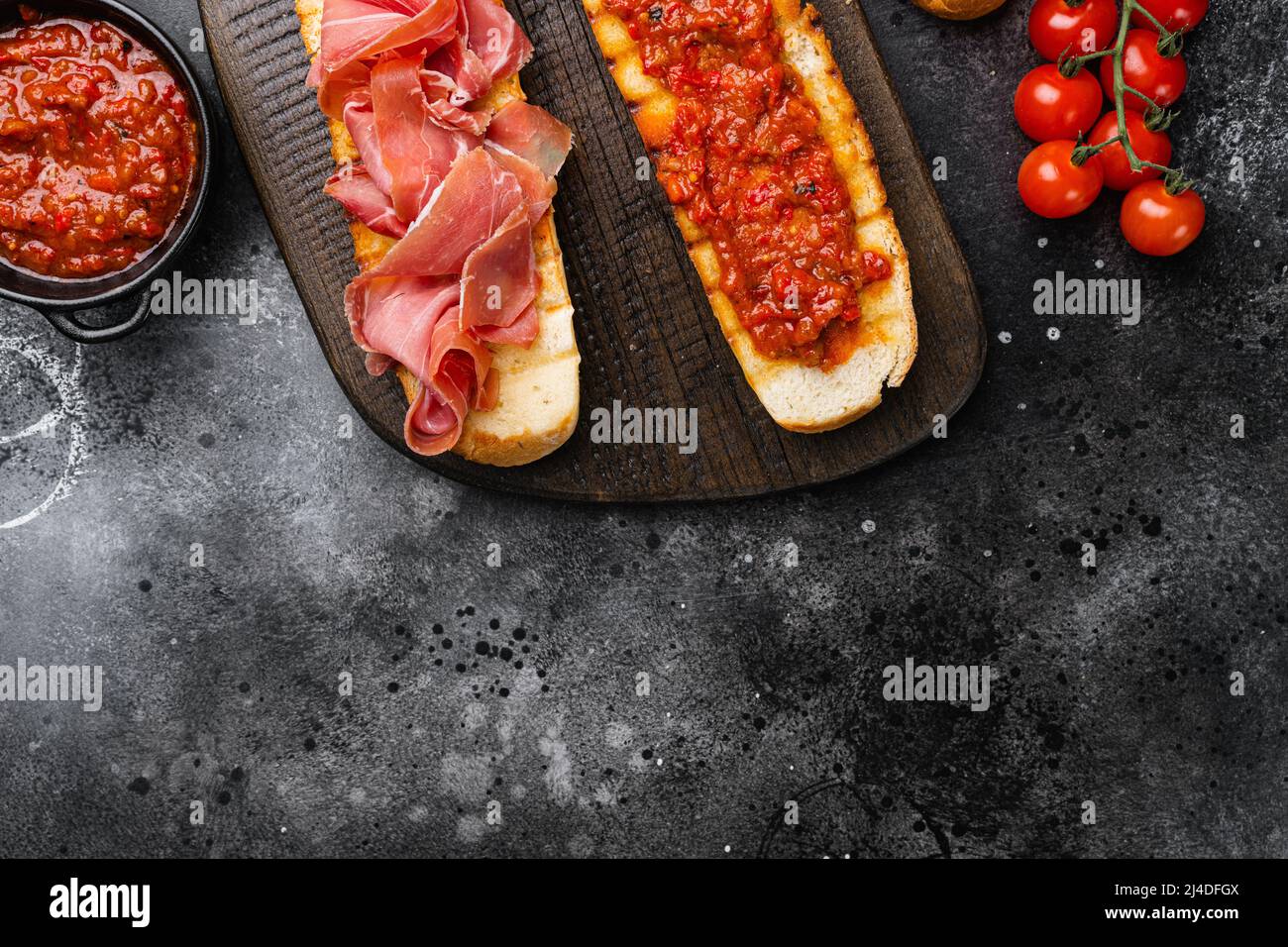 Italian tomato, prosciutto, jamon, ham and cheese bruschetta, on black ...