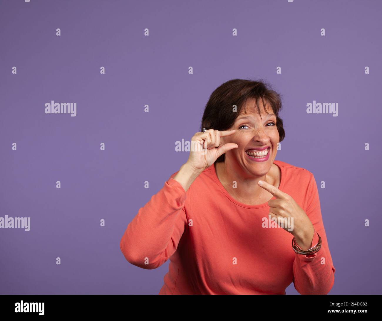 Woman laughing and making mocking gestures. Humourous woman teasing ...