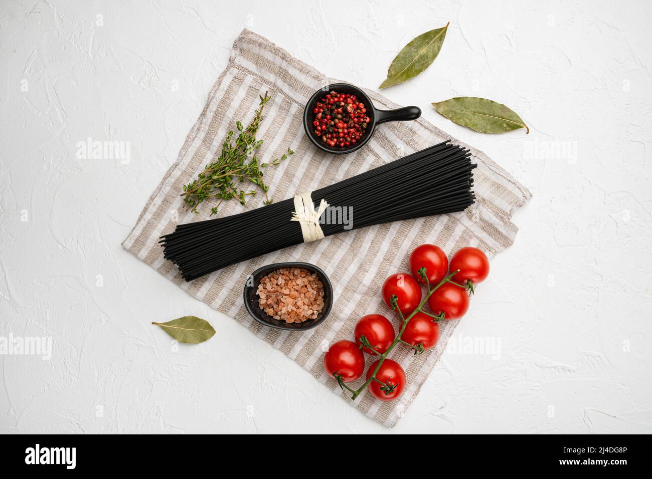 Black colored spaghetti raw dry, on white stone table background, top ...