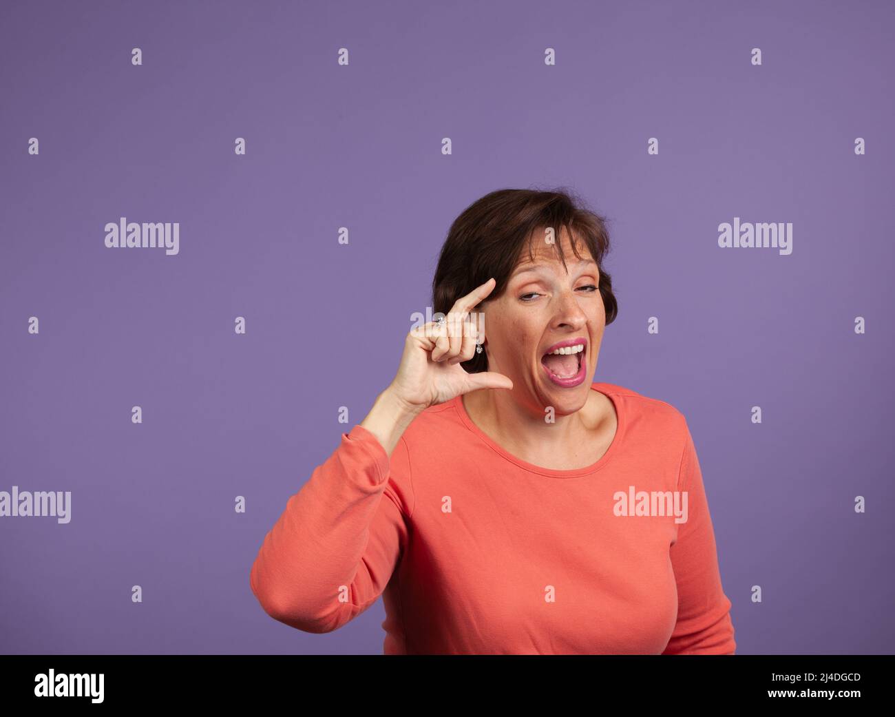 Woman laughing and making mocking gestures. Humourous woman teasing ...