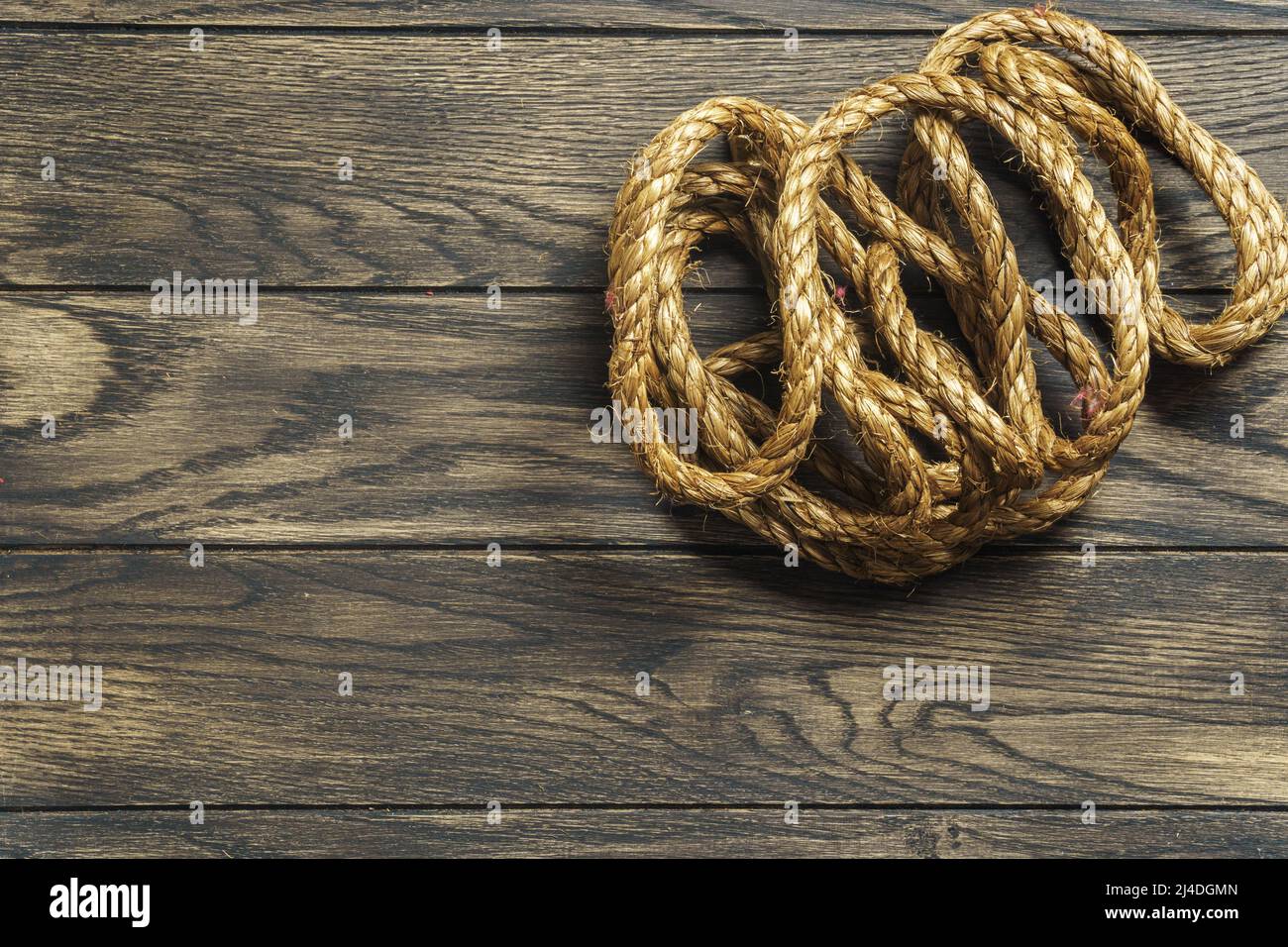Rolled rope on oak table with copy space. Natural wooden background ...