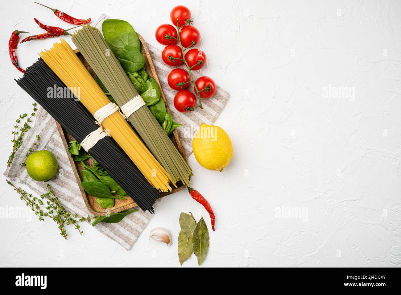 Colored spaghetti raw dry, on white stone table background, top view ...