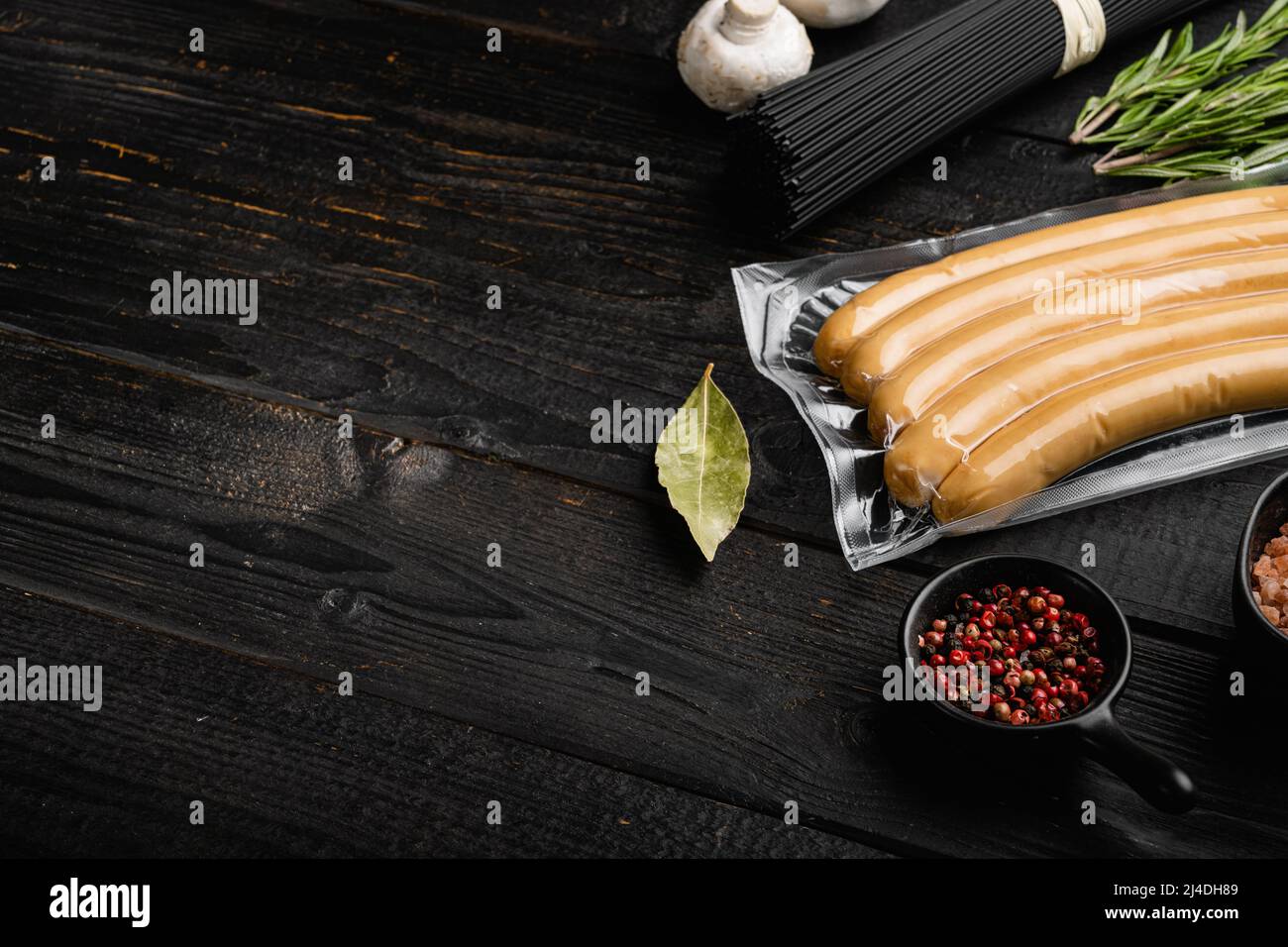 Raw chicken sausages in vacuum package set, on black wooden table ...