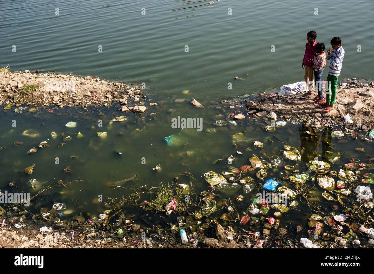 Environmental issues in India. Children playing near dirty littered ...