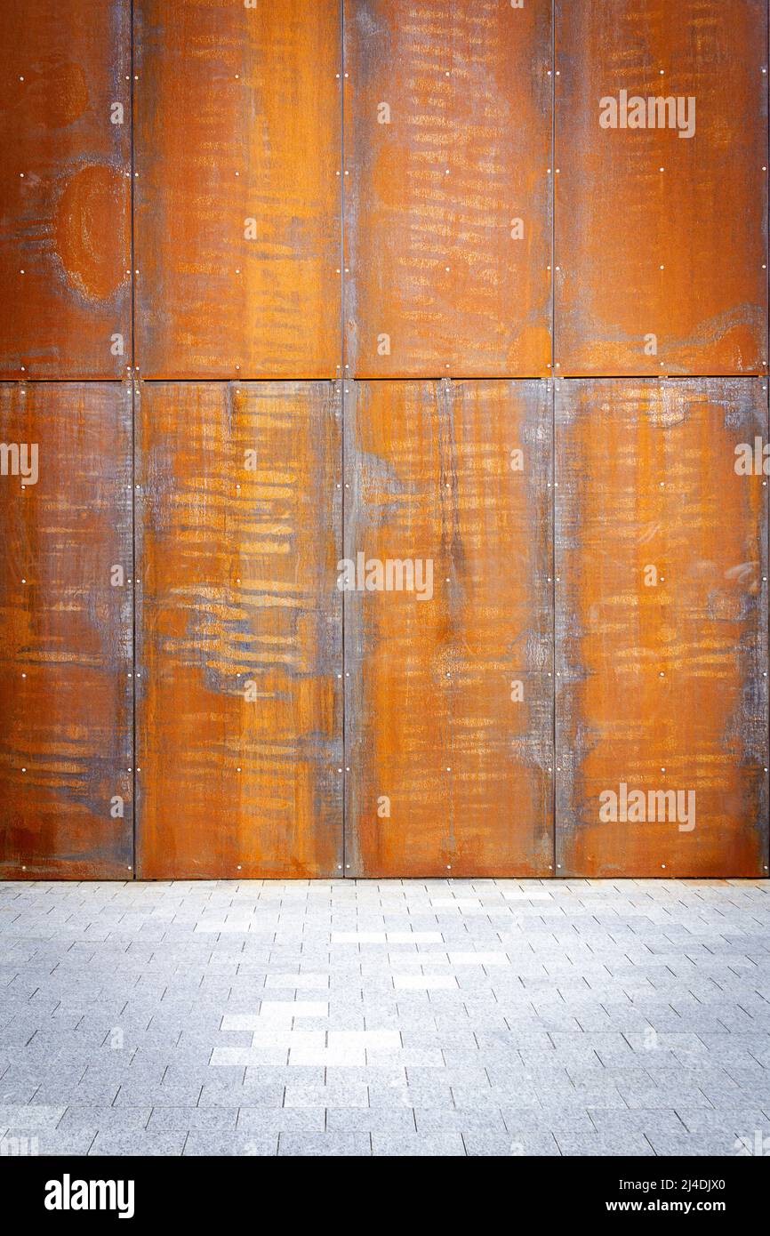 Modern architecture rusty metal wall and a sidewalk Stock Photo - Alamy