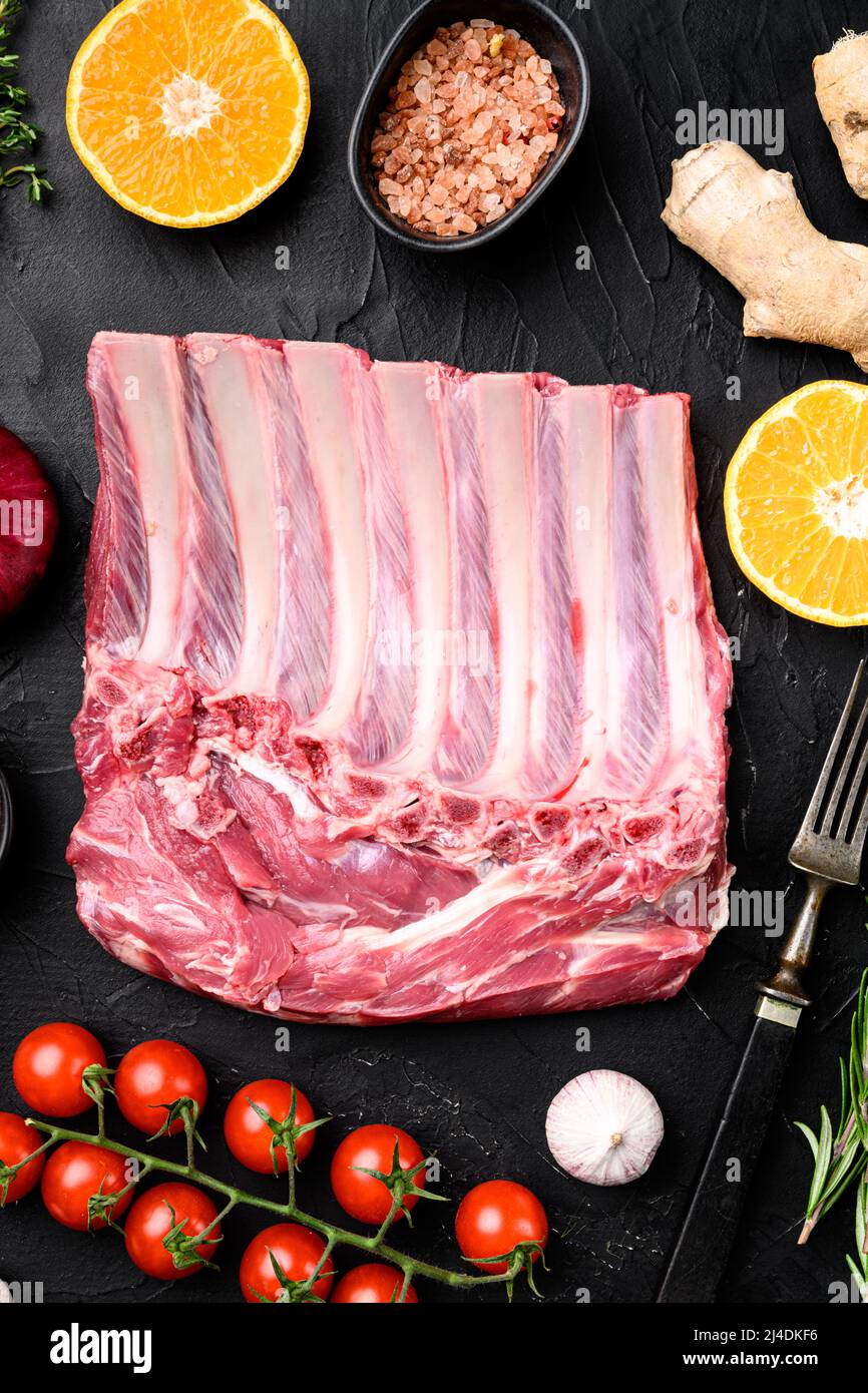 Frenched rack of lamb Mutton, on black dark stone table background, top ...