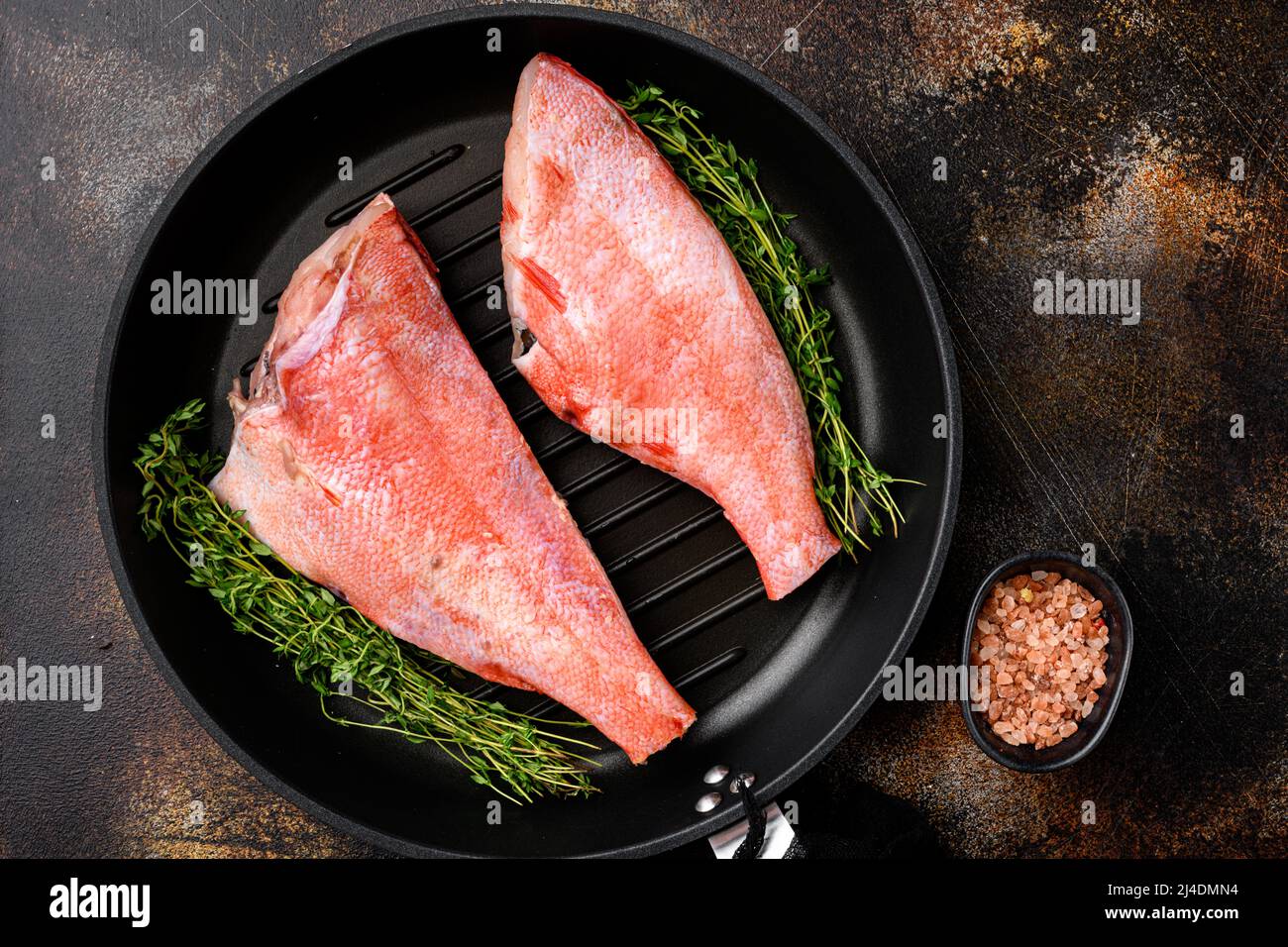 Fresh sea ocean red perch fish, in frying cast iron pan, on old dark ...