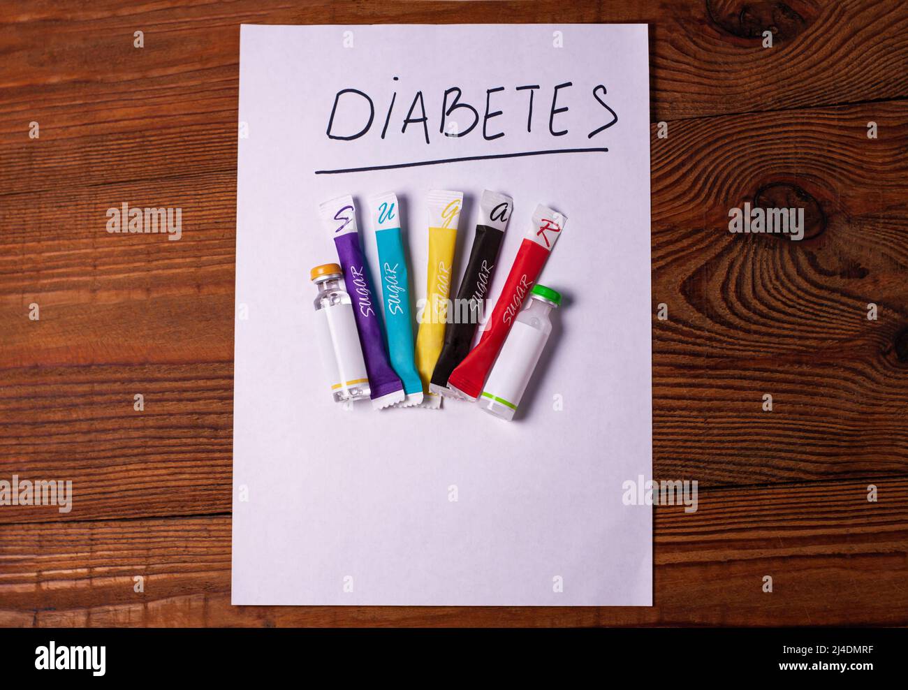 Diabetes sign on a white paper with insulin ampoules, colorful sugar ...