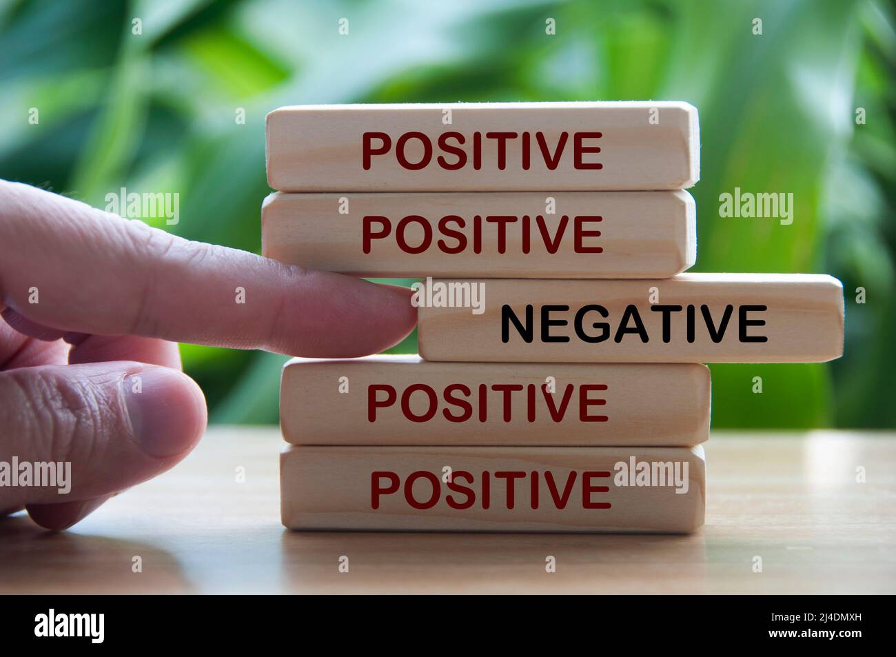 Hand pushing out negative out from positive - text on wooden blocks ...
