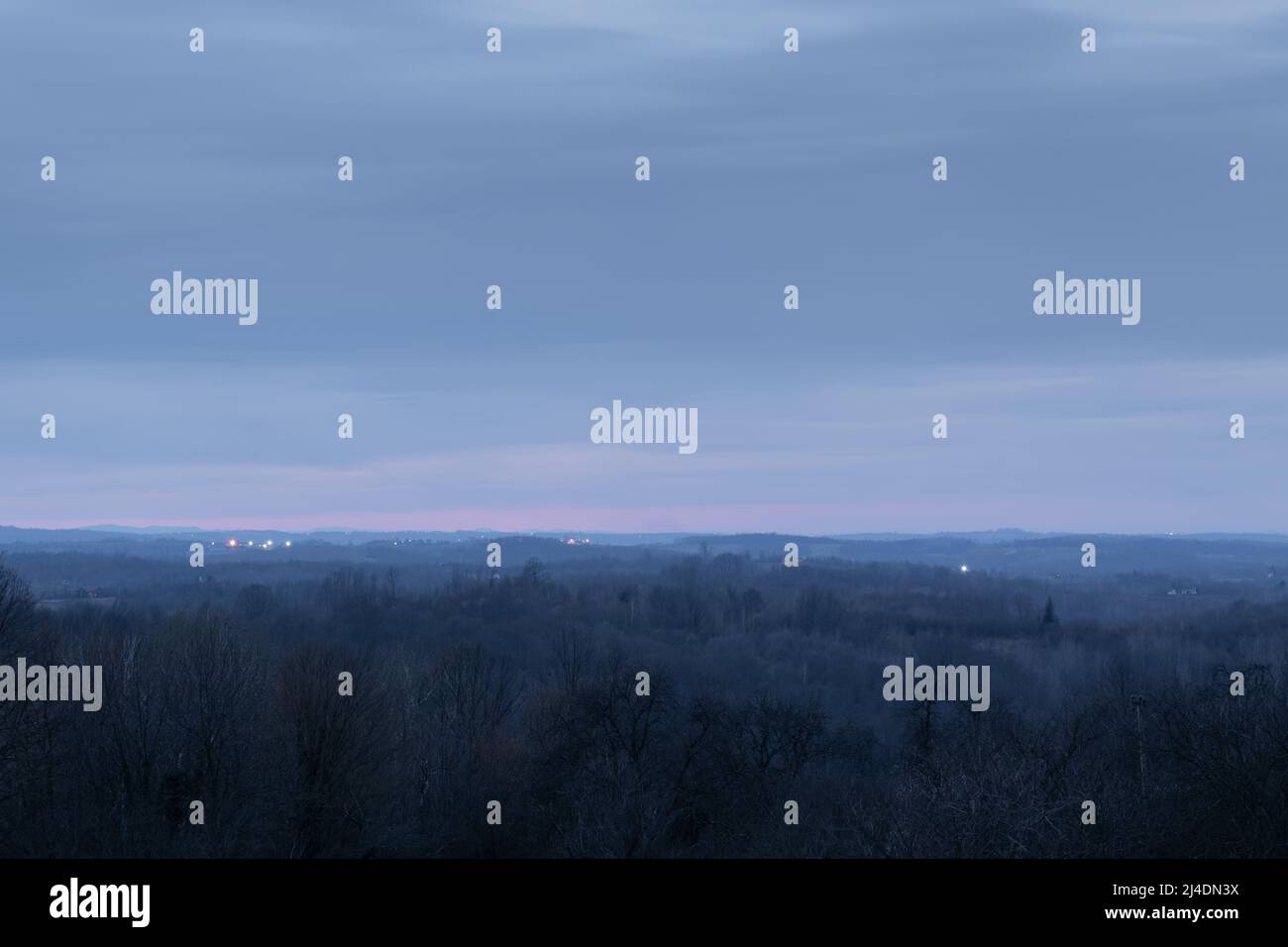 Dull overcast rural landscape, gloomy evening with haze and light on ...