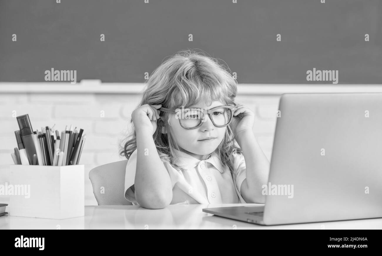 concentrated child boy in glasses study online in school classrrom with ...