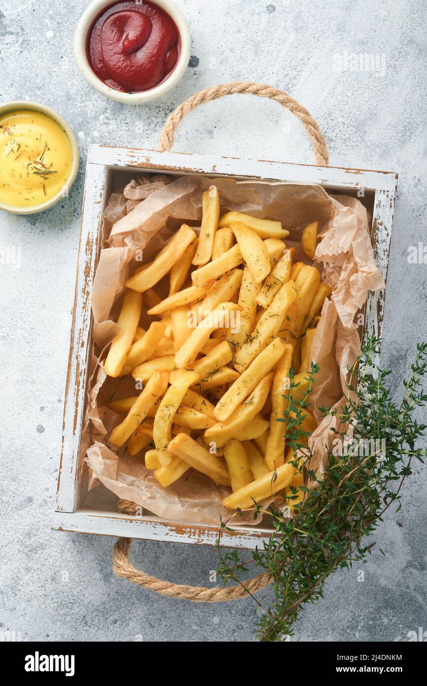 French fries. Tasty French fries server on parchment paper on wooden ...