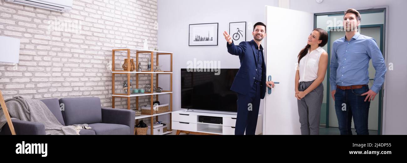 Happy Realtor Showing New Modern House To Customers Stock Photo - Alamy