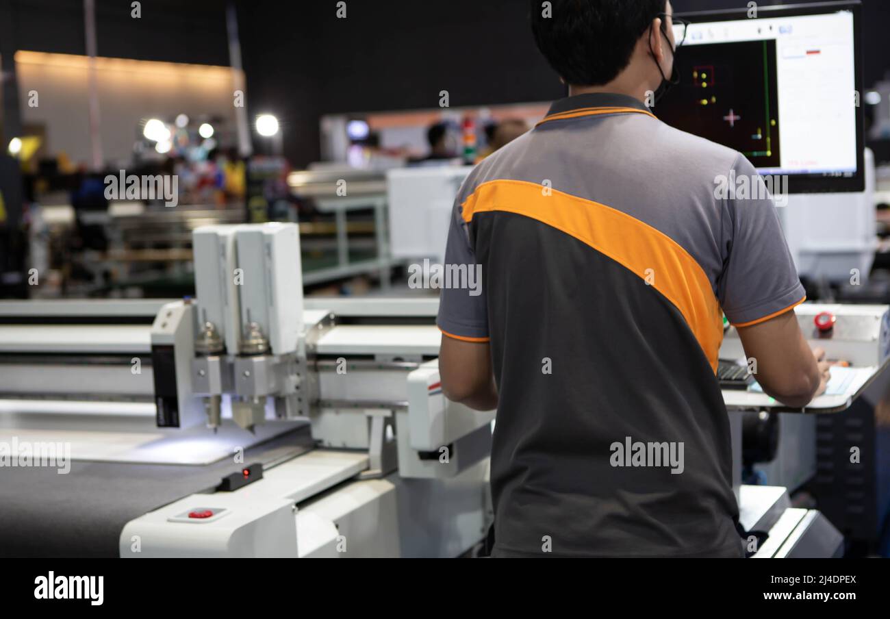 Industrial technician operating CNC laser cutting machine. Industrial ...