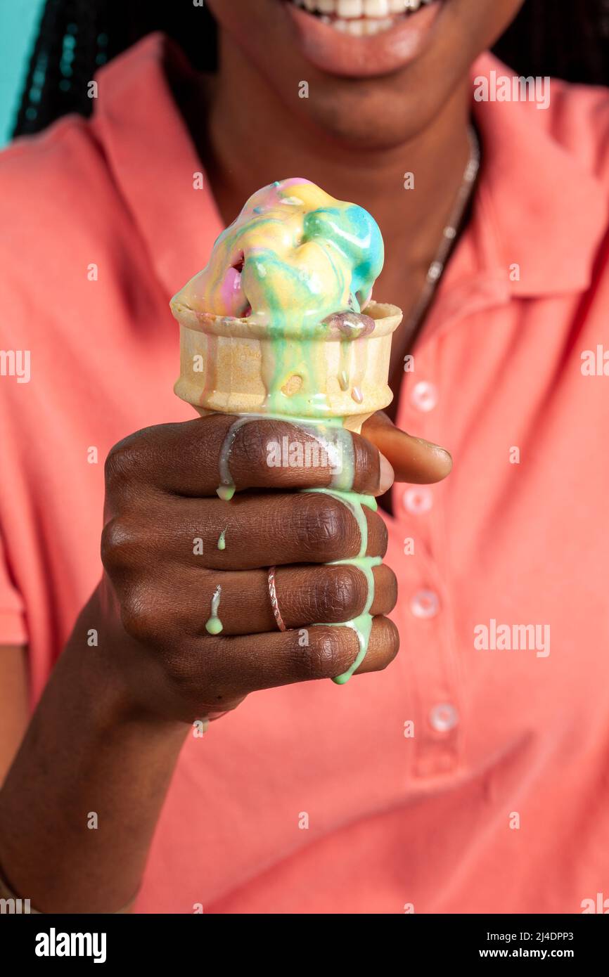 Close up of a dripping ice cream cone being eaten by an African ...