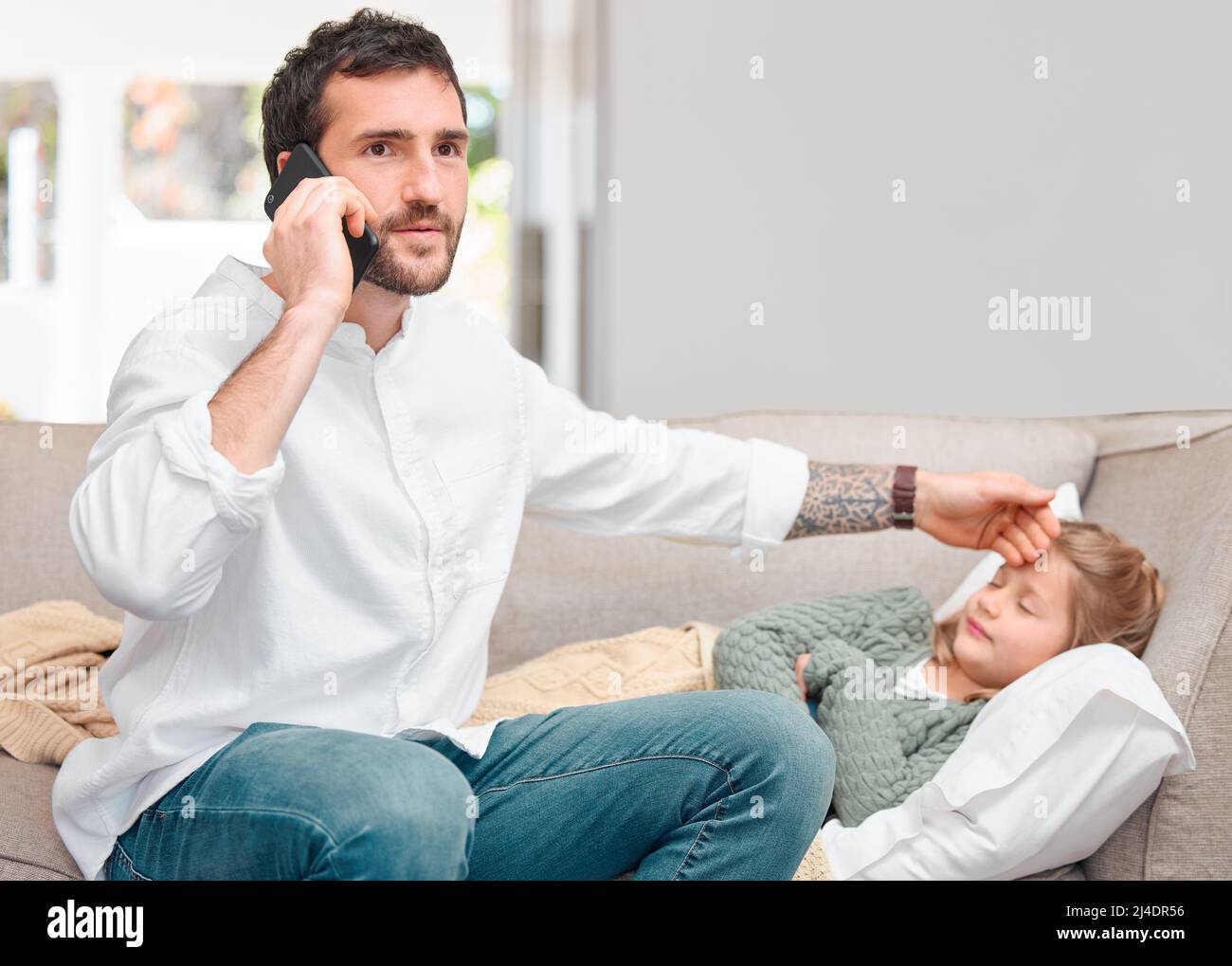 Dad knows when to get help. Shot of a father calling the doctor for his ...