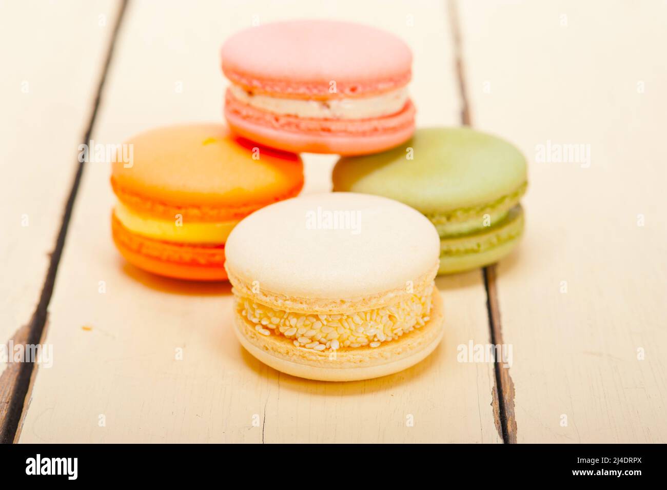 colorful french macaroons over a white rustic wood table Stock Photo ...