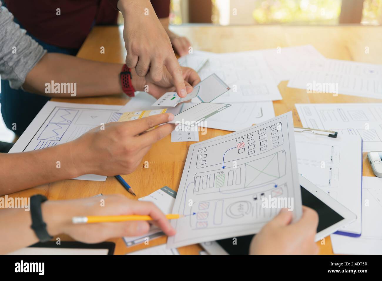 UX or UI designers discussing and designing on digital tablet and ...