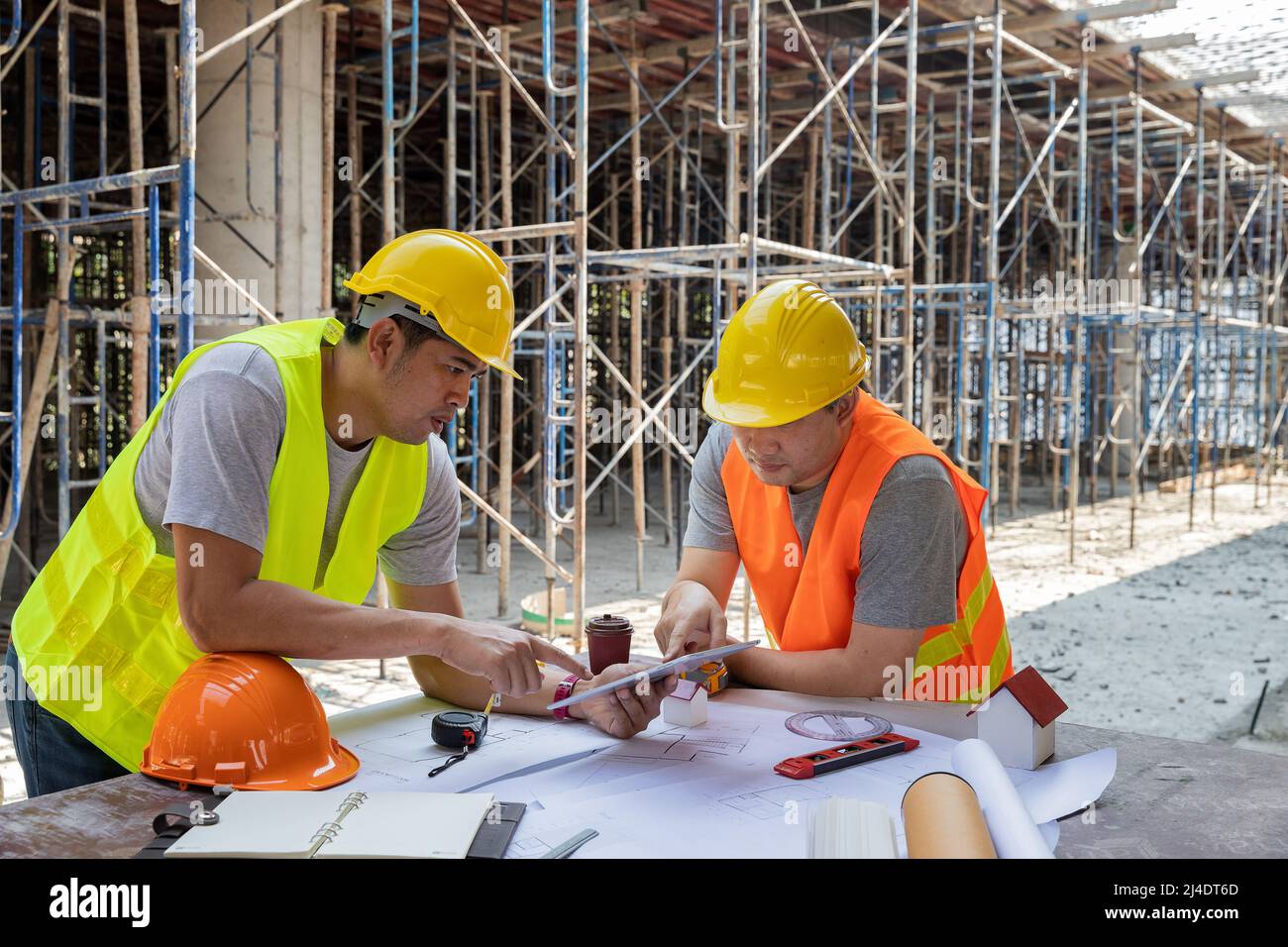 Engineer discussing with foreman about project in building construction ...