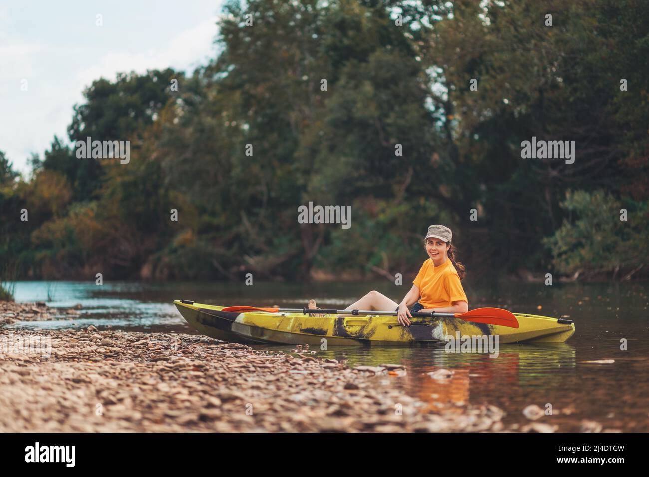 World Tourism Day. A young happy woman is sitting relaxed in a yellow ...