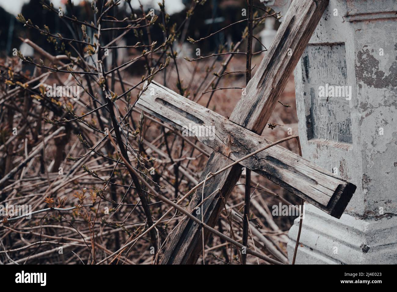 Toppled wooden cross and damaged gravestone at abandoned cemetery. Old ...