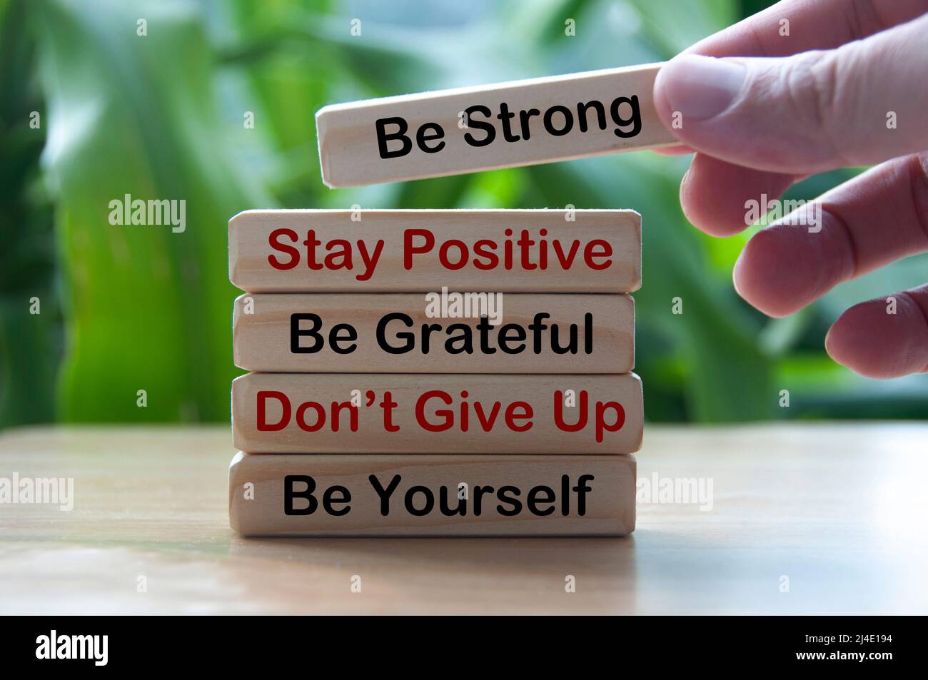 Self-help motivational text on wooden blocks with hand holding a wooden ...