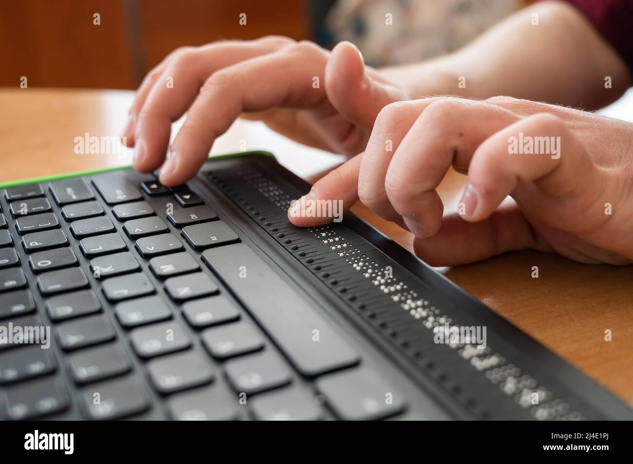 A blind man uses a computer with a Braille display and a computer ...