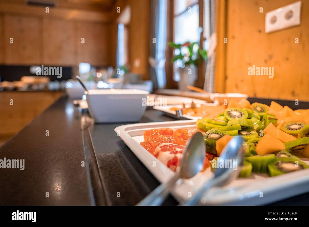Various healthy sliced fruits served in plate on counter at luxurious ...