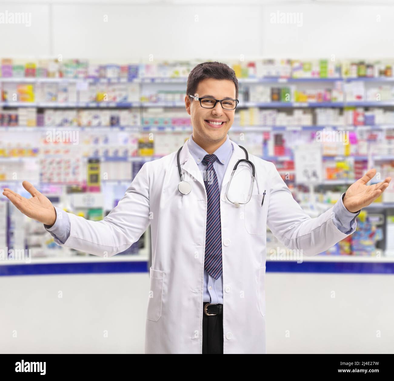 Pharmacist making a welcome gesture and smiling inside a chemist store ...