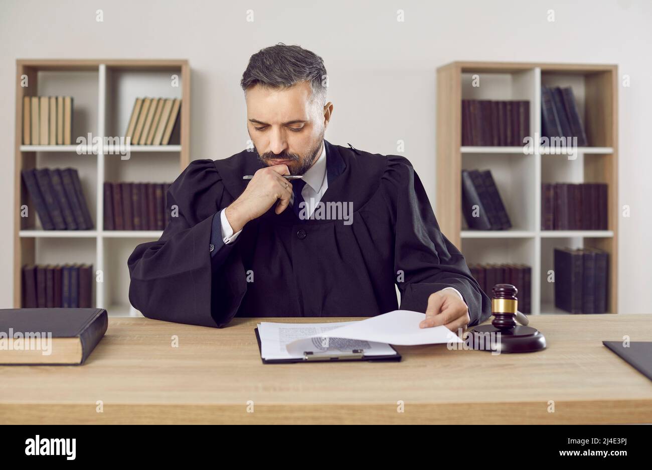 Judge, lawyer or attorney sitting at his table, studying some documents ...