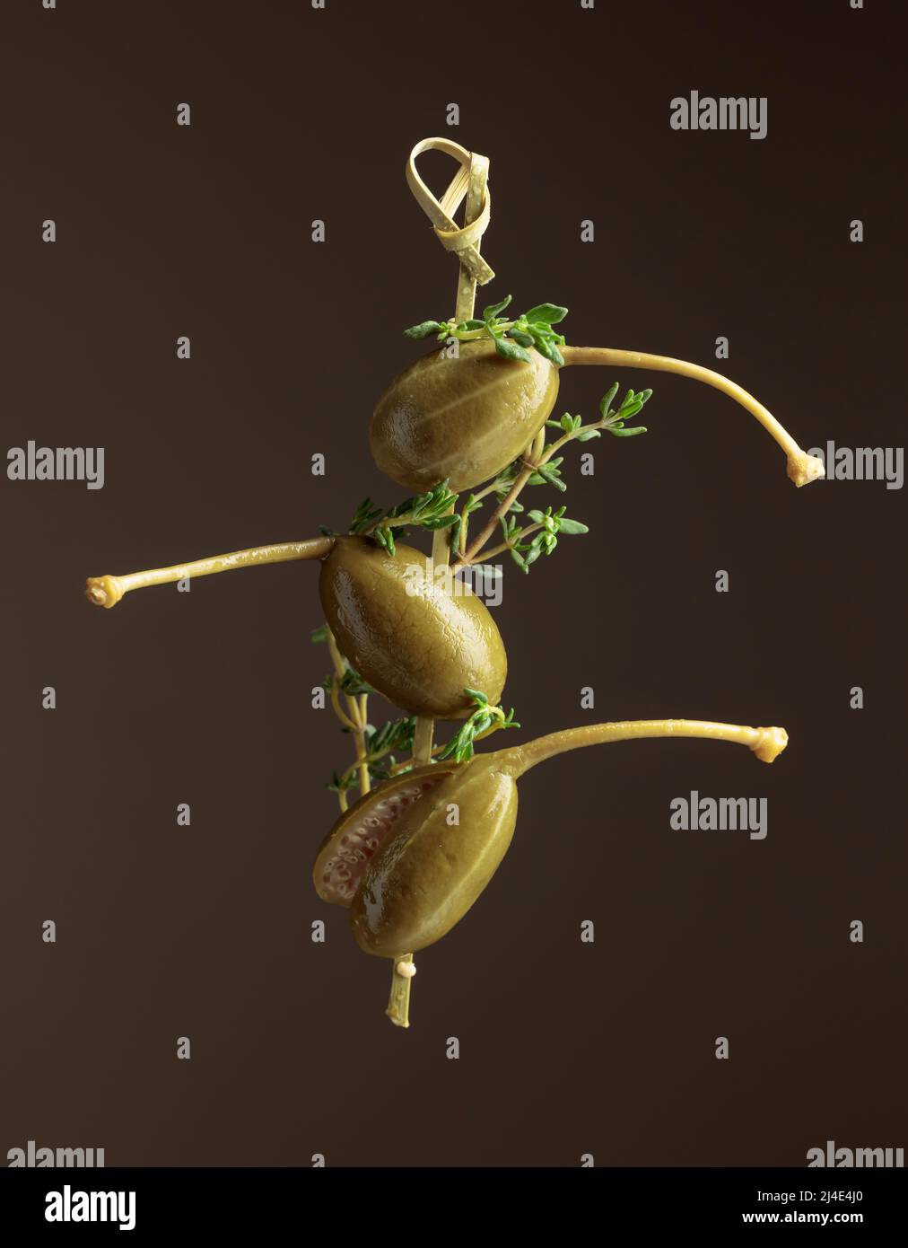 Large pickled canned capers with thyme on a bamboo stick Stock Photo ...