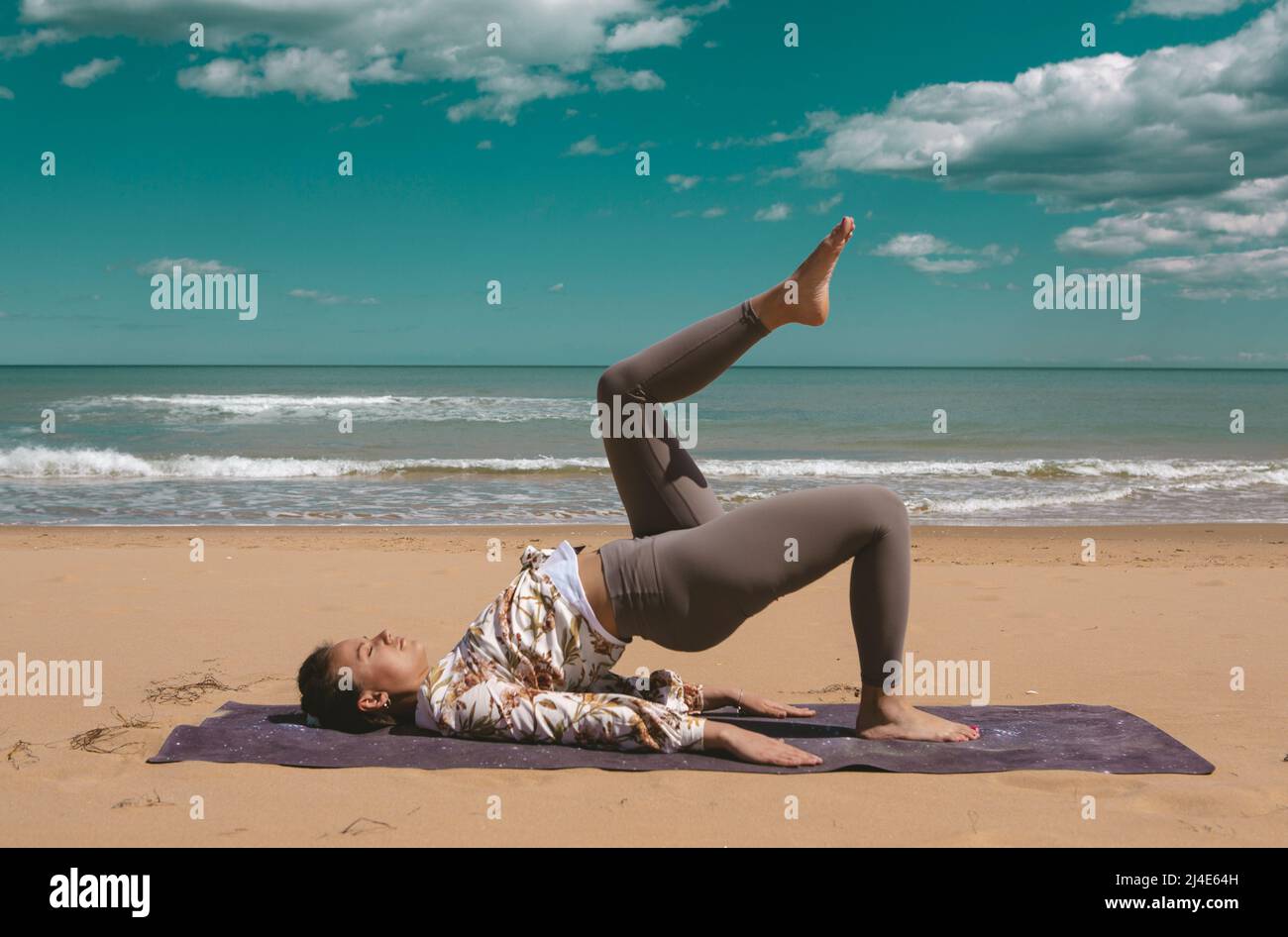 female athlete performing pilates exercise on the beach Stock Photo - Alamy